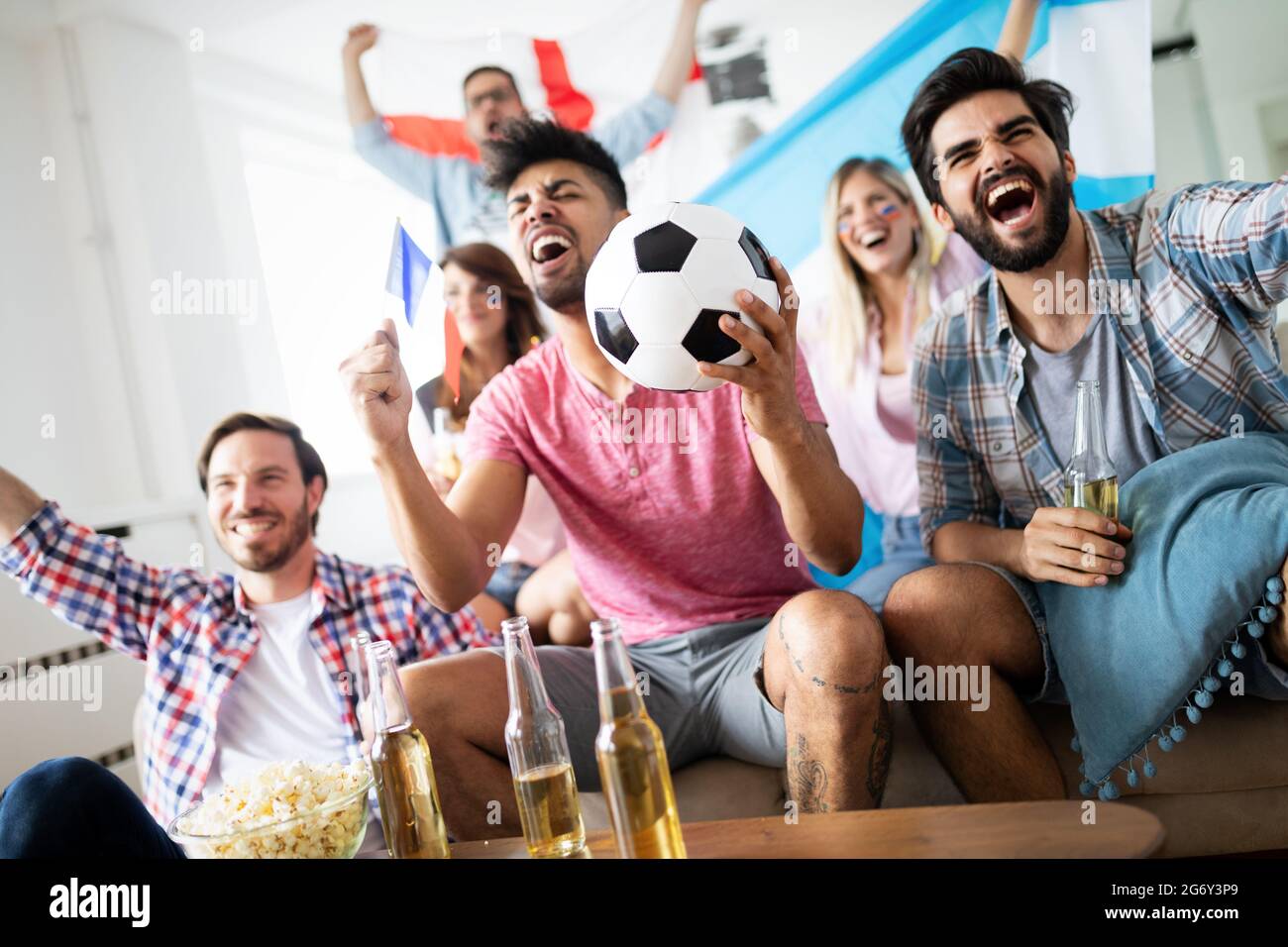 Group of friends having fun at home, watching game and enjoying ...