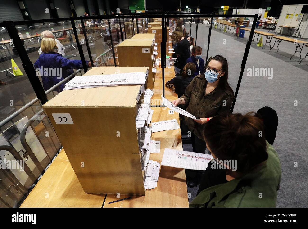 Election staff sort ballot papers behind perspex screens during the ...