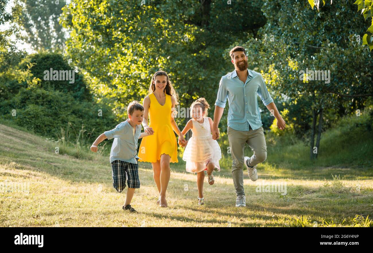 Active young parents with a healthy lifestyle running together with ...