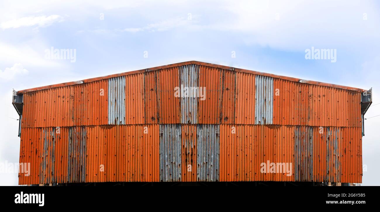 exterior godown building with rusty zing wall on blue skyin landscape ...