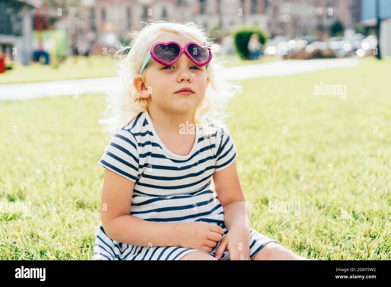 Crisis age 3 years. Serious child girl looks into the camera angrily ...