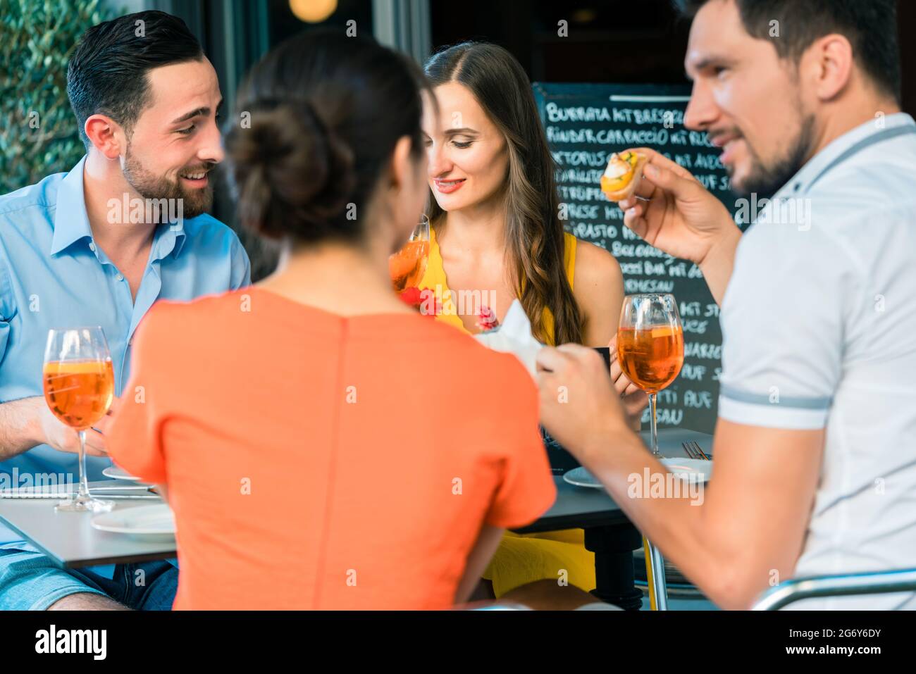 Cheerful young best friends toasting with a refreshing delicious summer ...