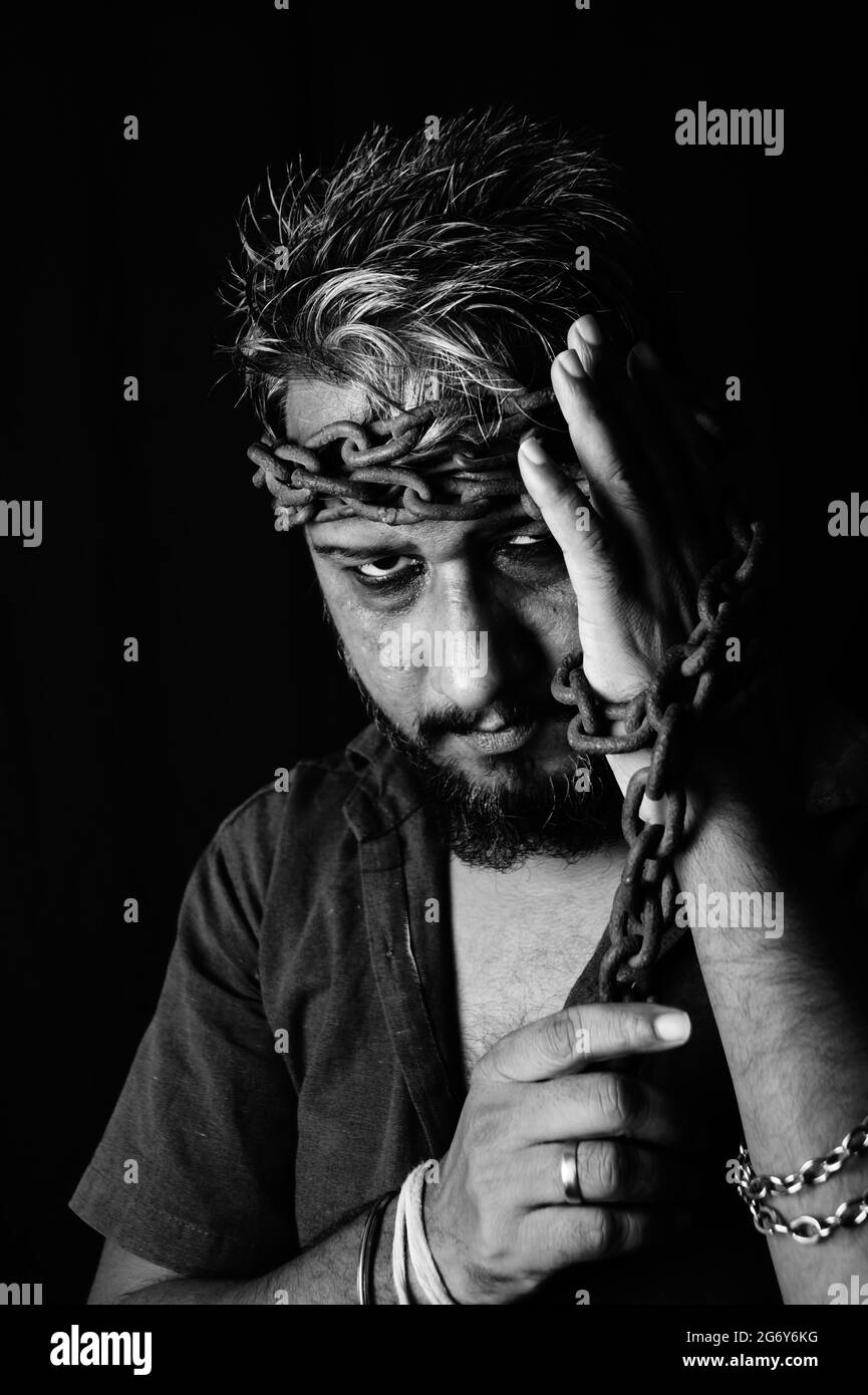 Grayscale portrait of a man with a serious face and with chained head ...