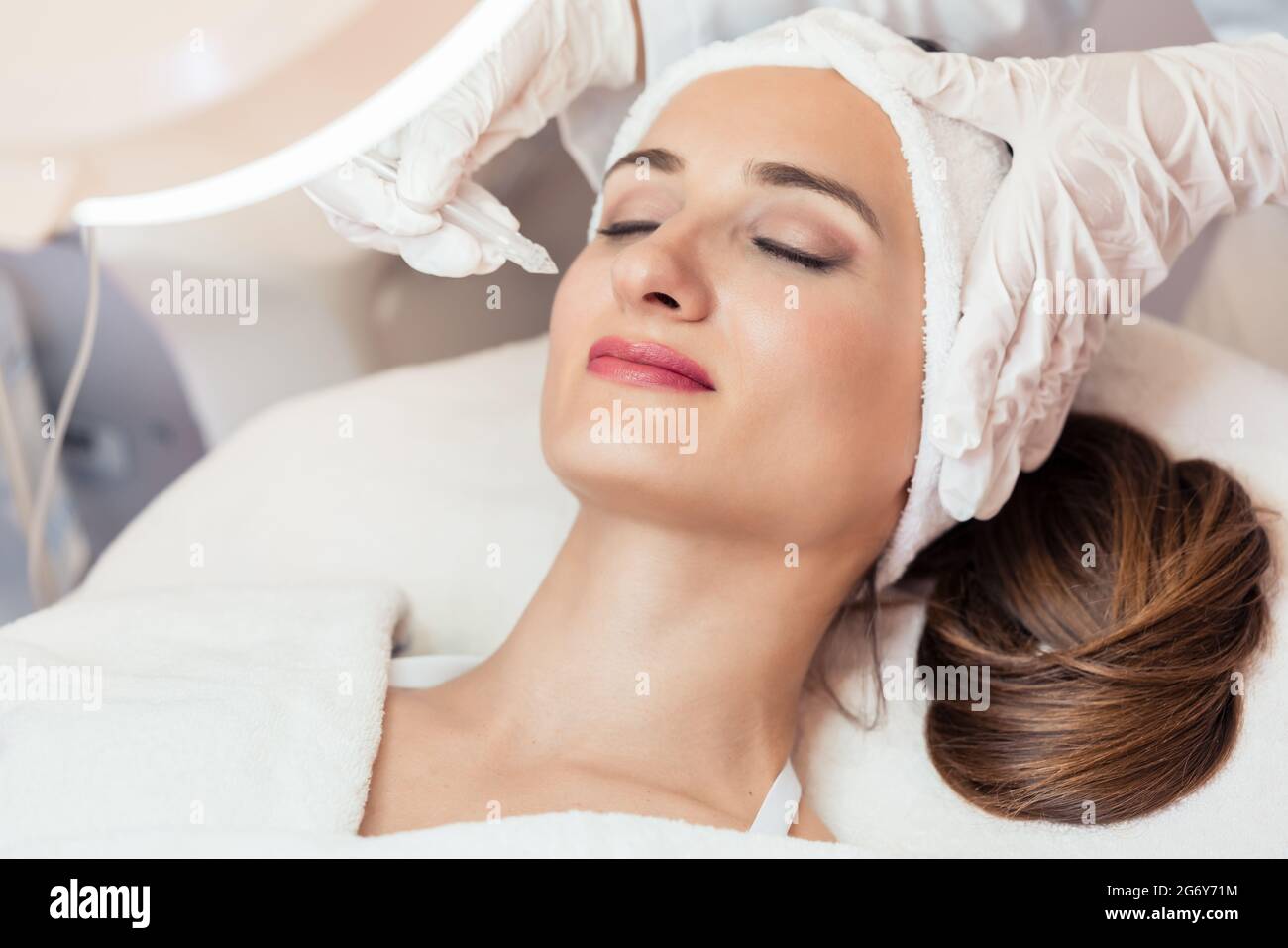Beautiful woman relaxing during non-invasive facial treatment for ...