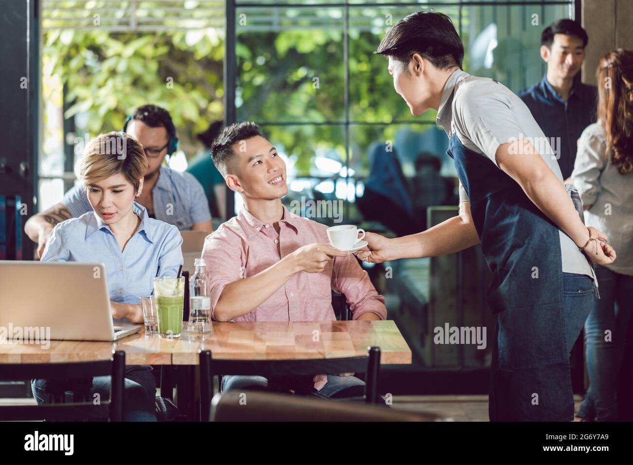 Young smiling couple at a cafe with waiter serving cop of coffee Stock ...