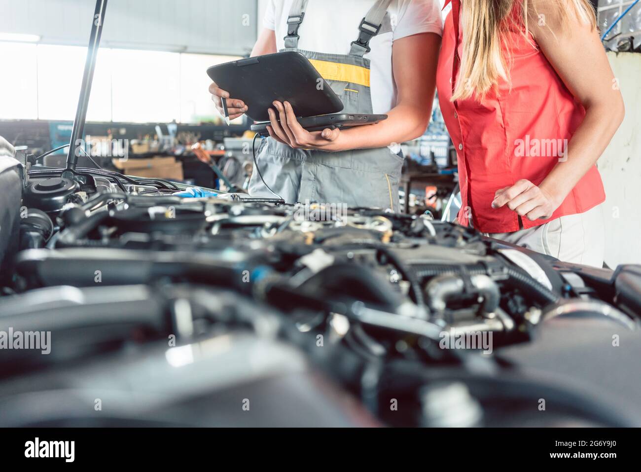 Close-up of the hand of an auto mechanic opening the oil reservoir ...