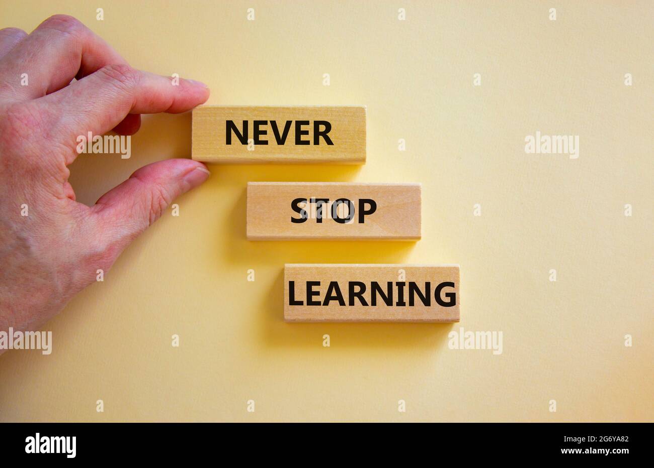 Never stop learning symbol. Wooden blocks with concept words Never stop ...