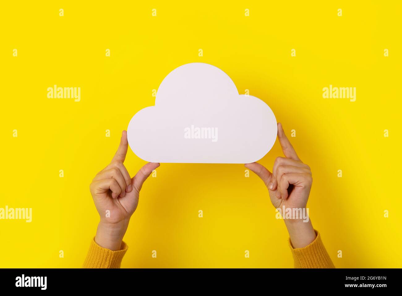 Cloud computing concept, hands holding cloud over yellow background ...