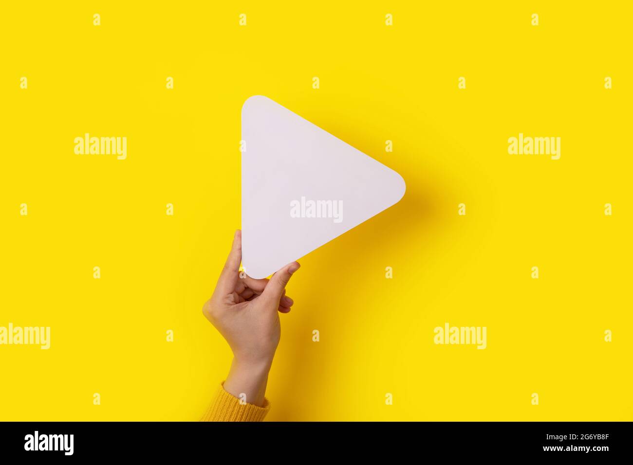 play symbol in hand over yellow background, multimedia concept Stock ...