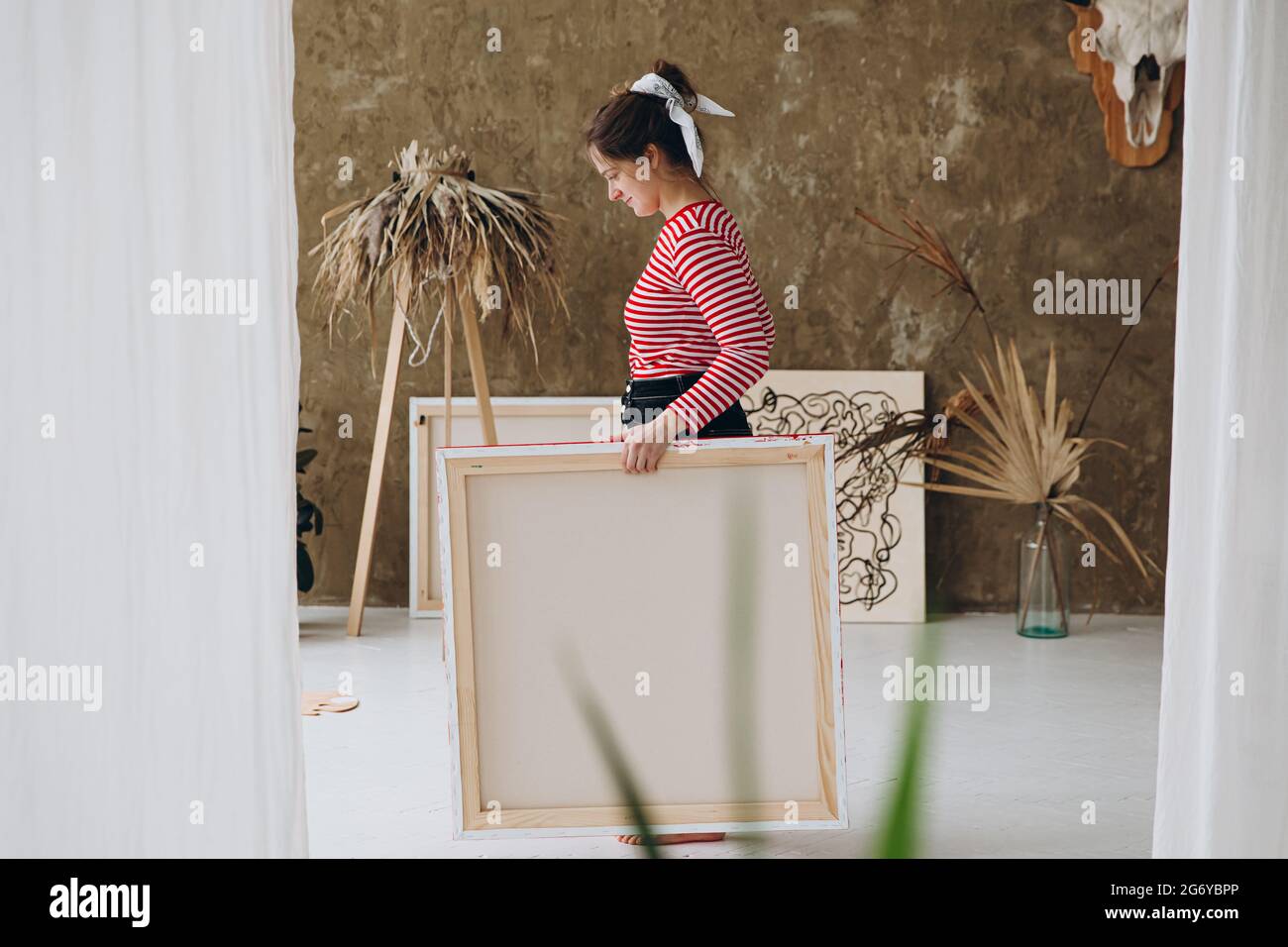 Side view of artist standing at art studio with canvas Stock Photo - Alamy