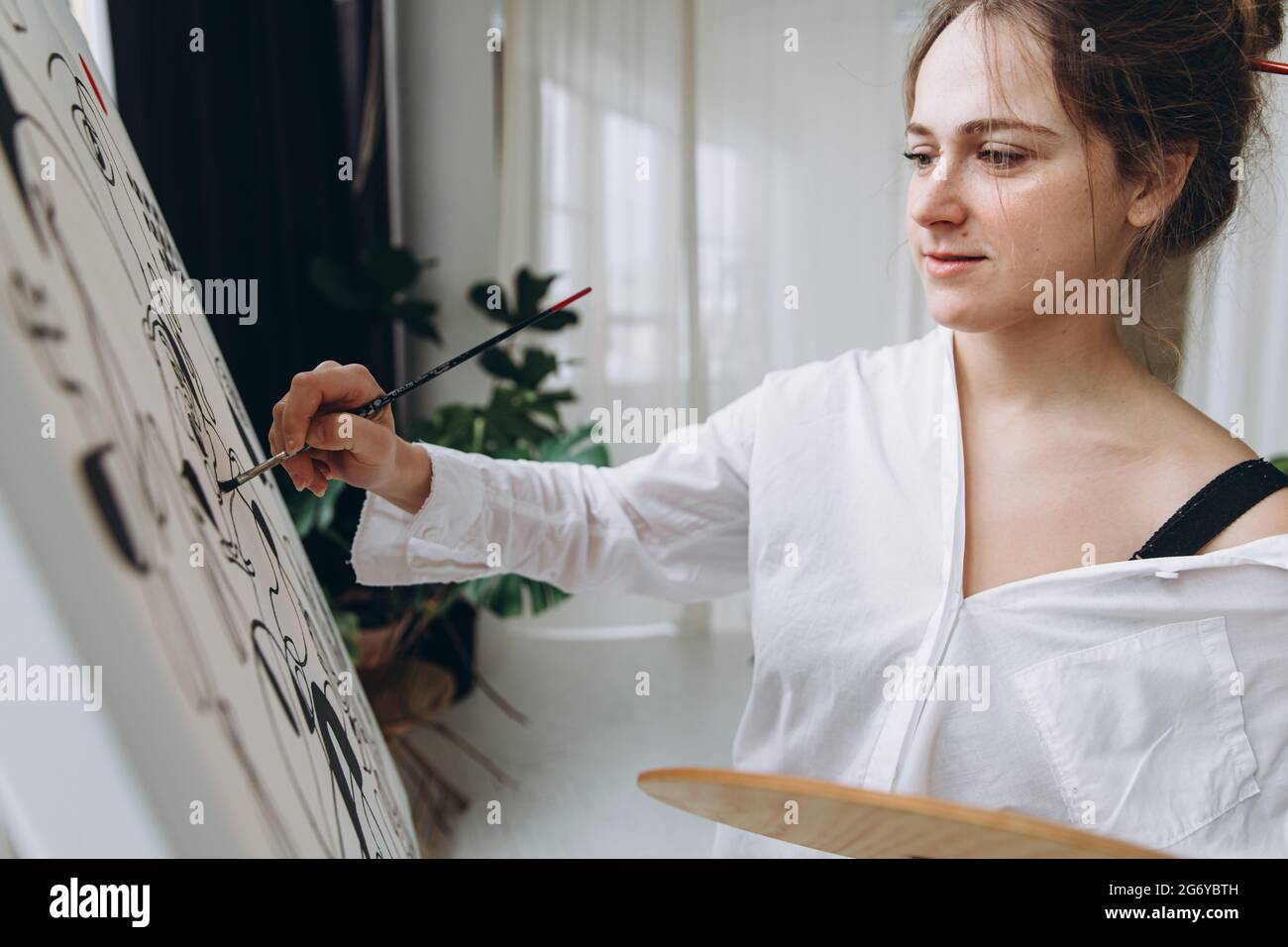 Beautiful female artist drawing picture on canvas Stock Photo - Alamy