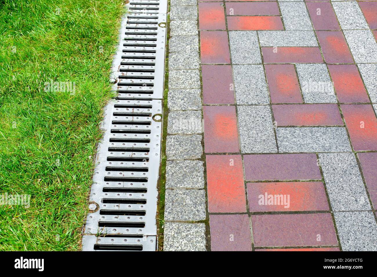 grating of drainage system rainwater in the park at the sidewalk from a ...