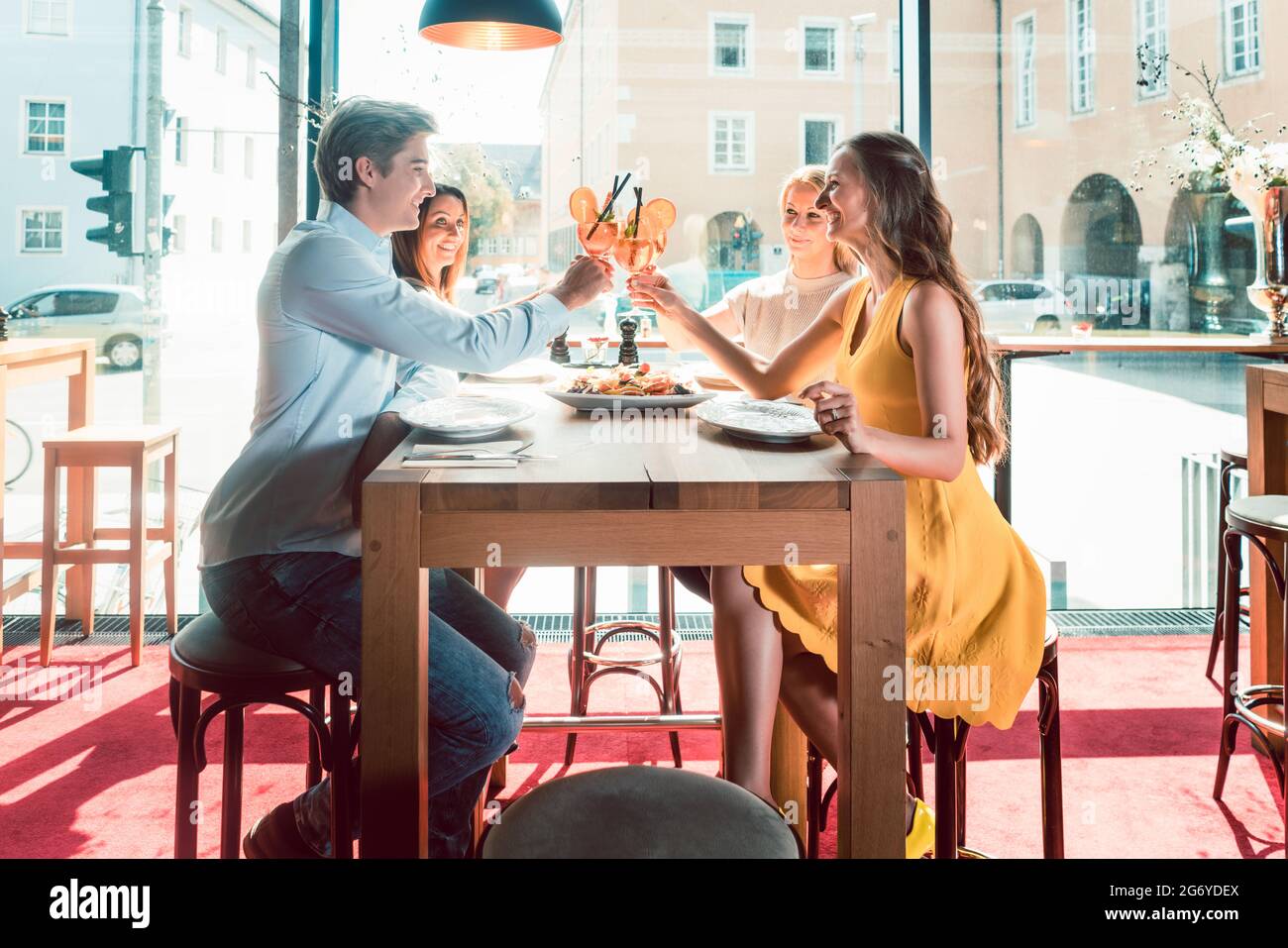 High-angle view of the hands of four young friends toasting with fresh ...