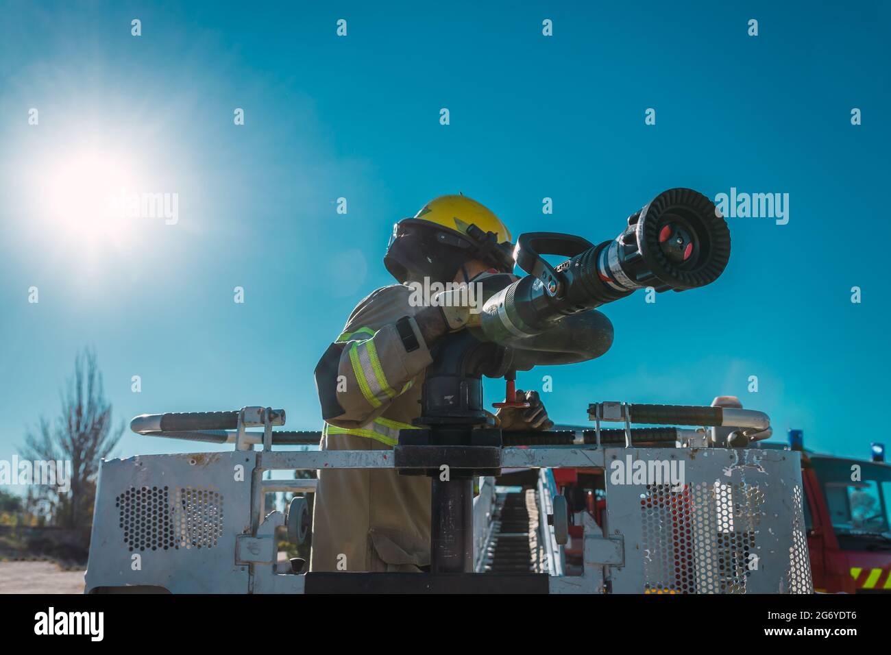 Firefighter on a ladder next to a lance, ready to launch pressurized ...