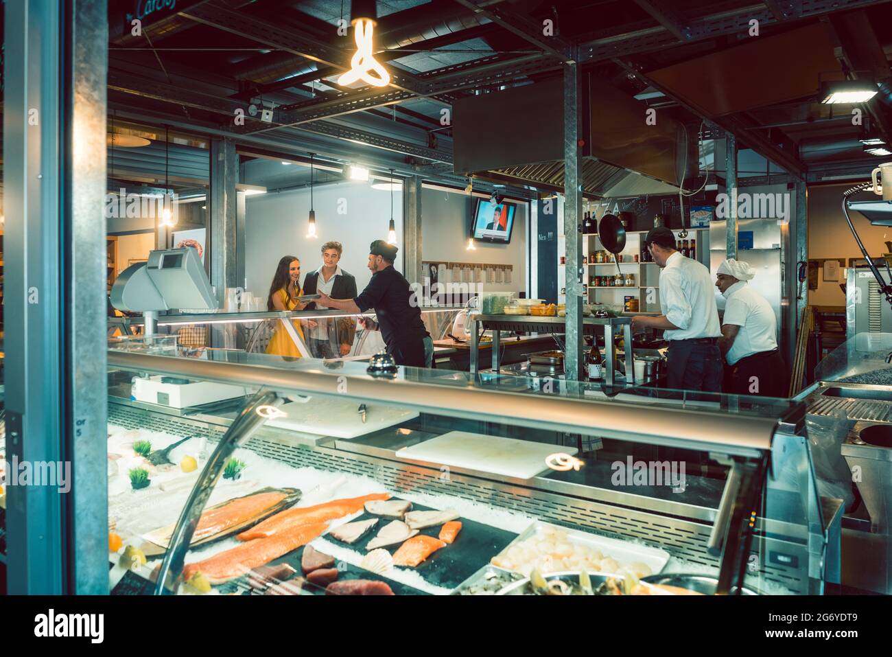 Young couple ordering food at the recommendation of an experienced chef ...