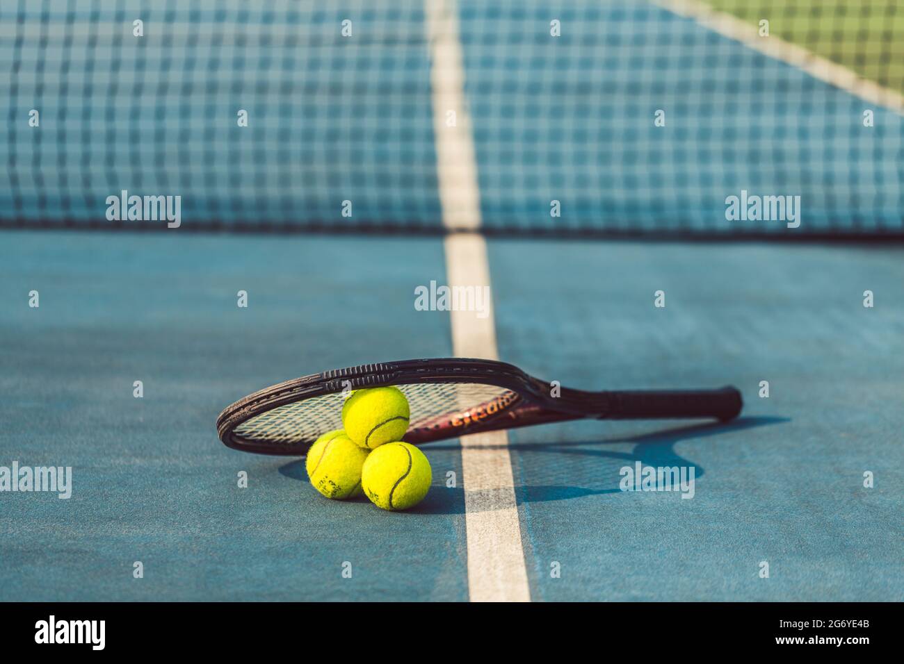 High-angle close-up of three fluorescent yellow tennis balls on a ...