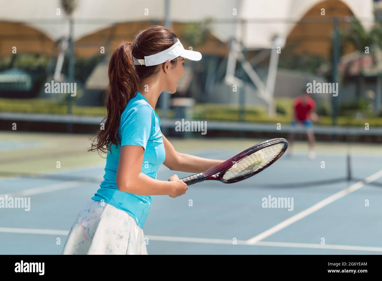 Side view of a beautiful and competitive woman smiling, while holding ...