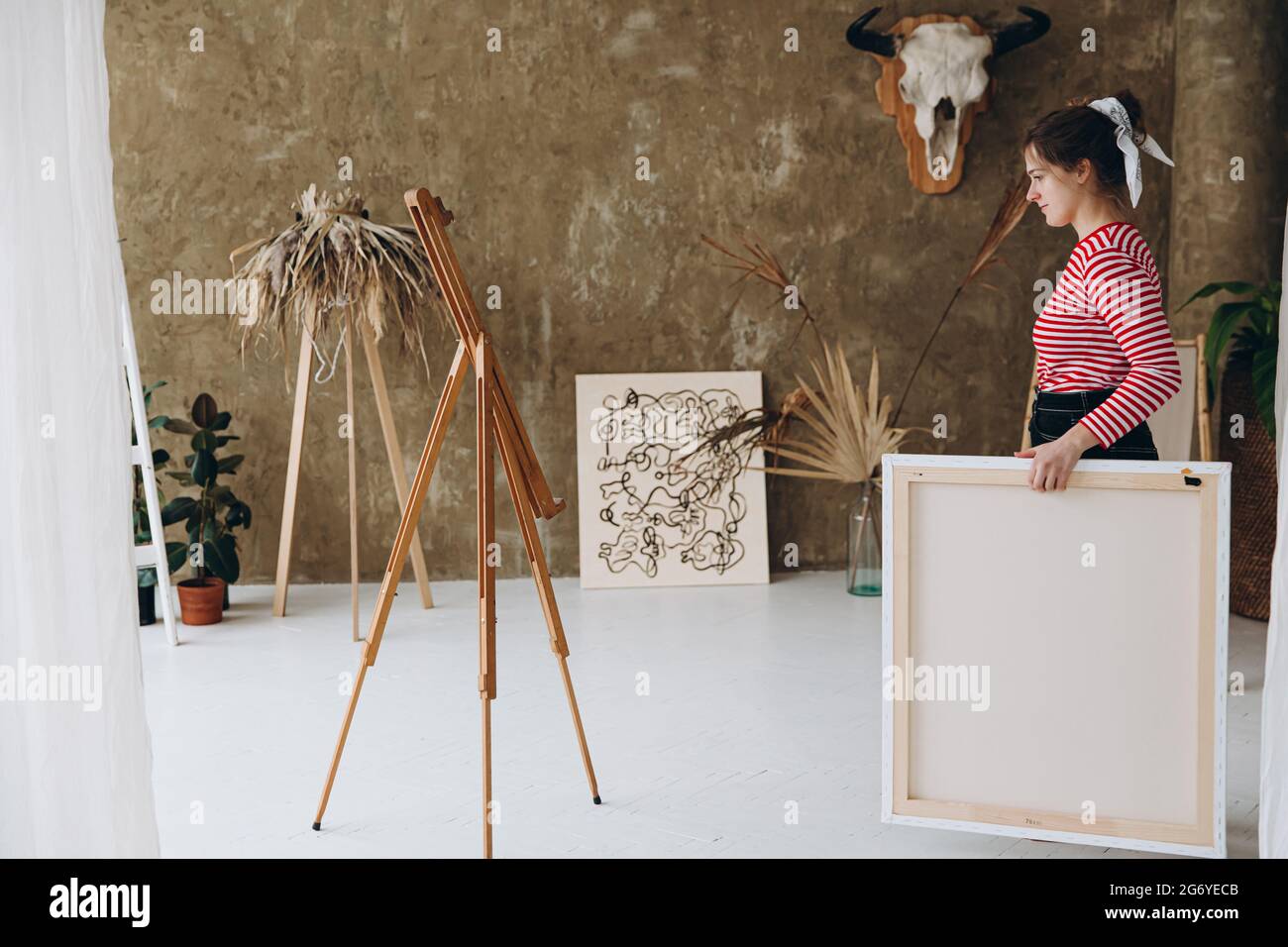 Talented woman carrying canvas for painting at studio Stock Photo - Alamy