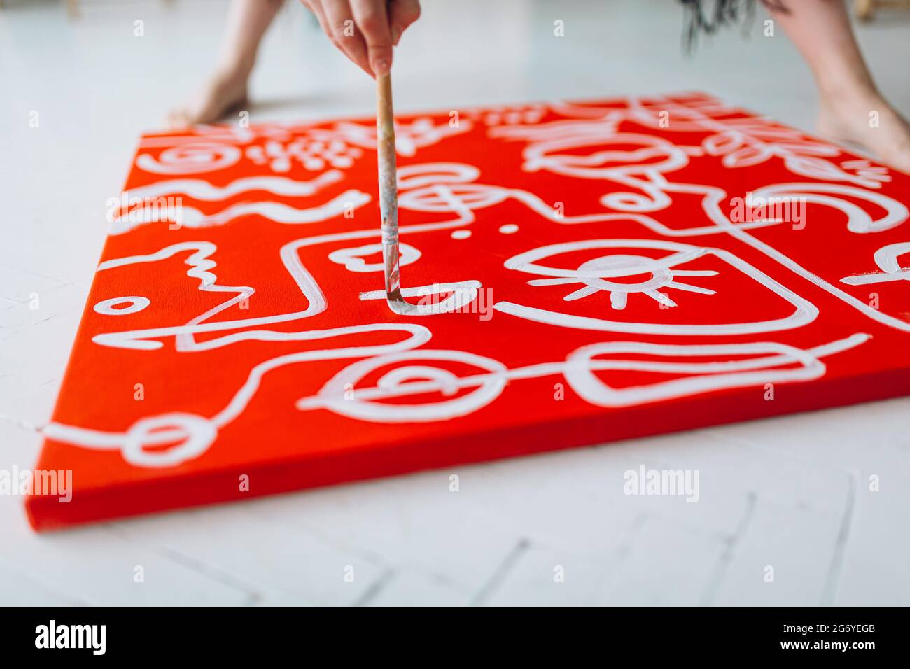 Close up of woman painting abstract drawing on red canvas Stock Photo ...