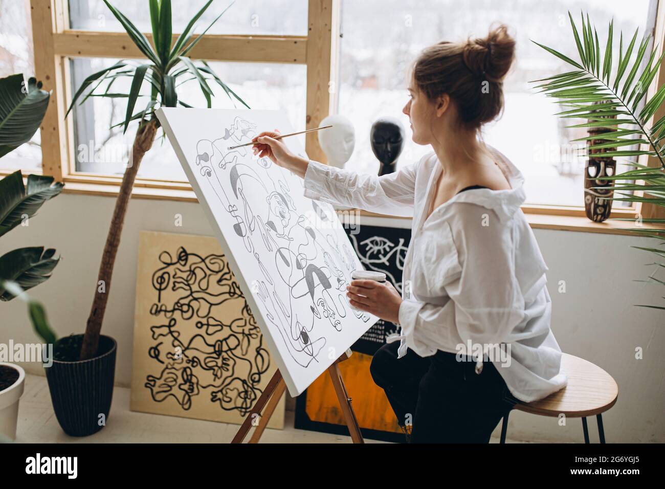 Pretty artist drawing black and white picture on canvas Stock Photo - Alamy