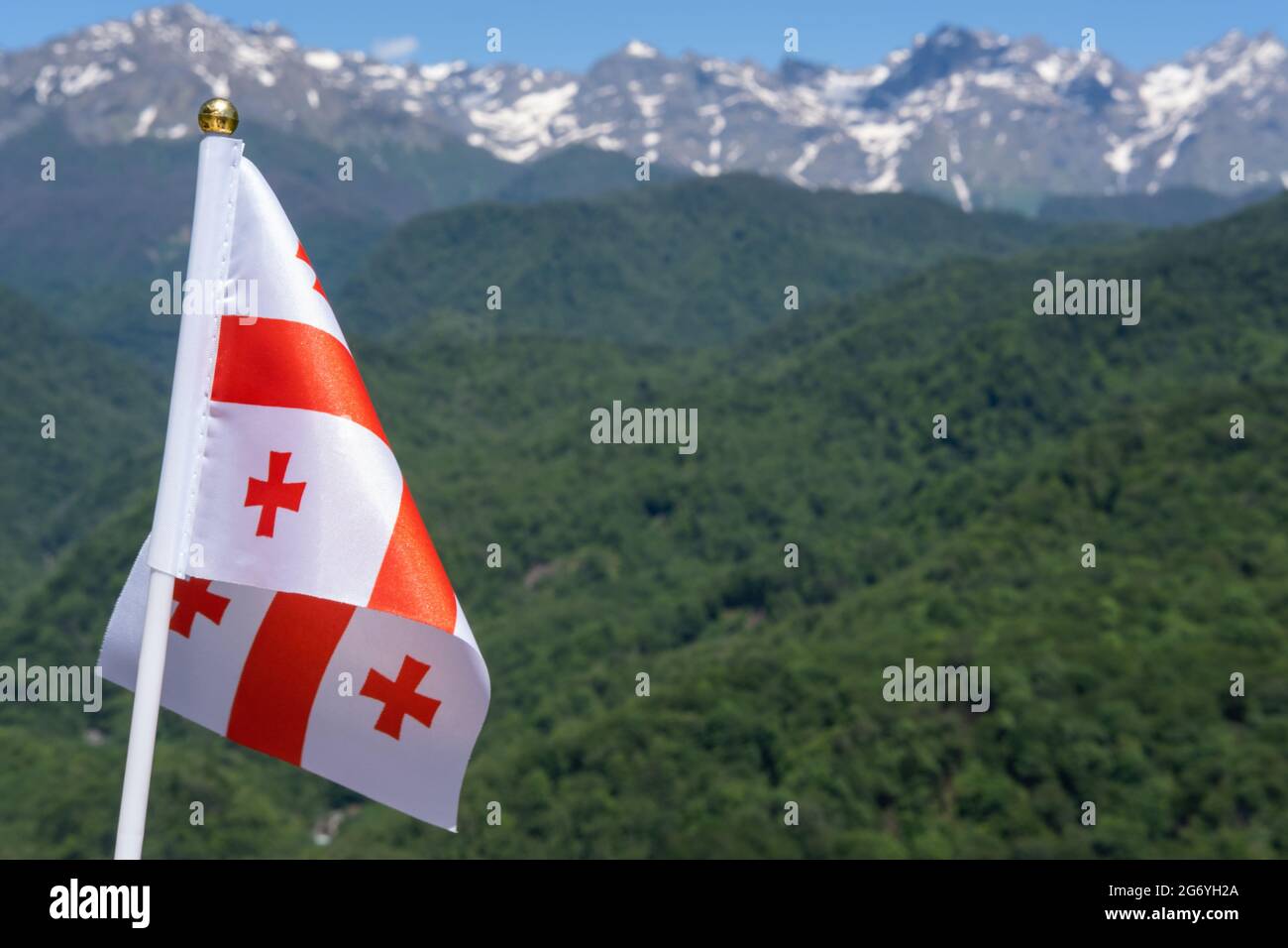 Georgia Flag Waving on Background of Mountains and Blue Sky Stock Photo ...