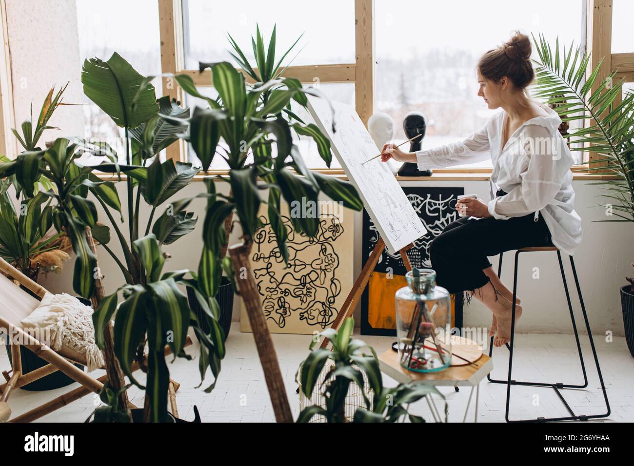 Side view of female artist painting on canvas Stock Photo - Alamy