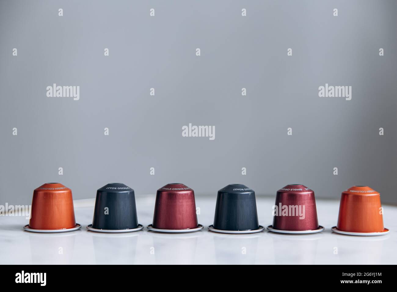 Row of six colorful coffee capsules Stock Photo - Alamy