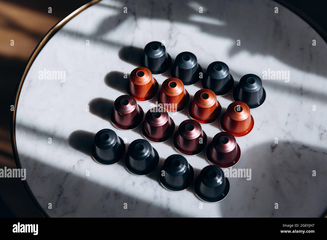 Four rows of coffee capsules with shadow on table Stock Photo - Alamy