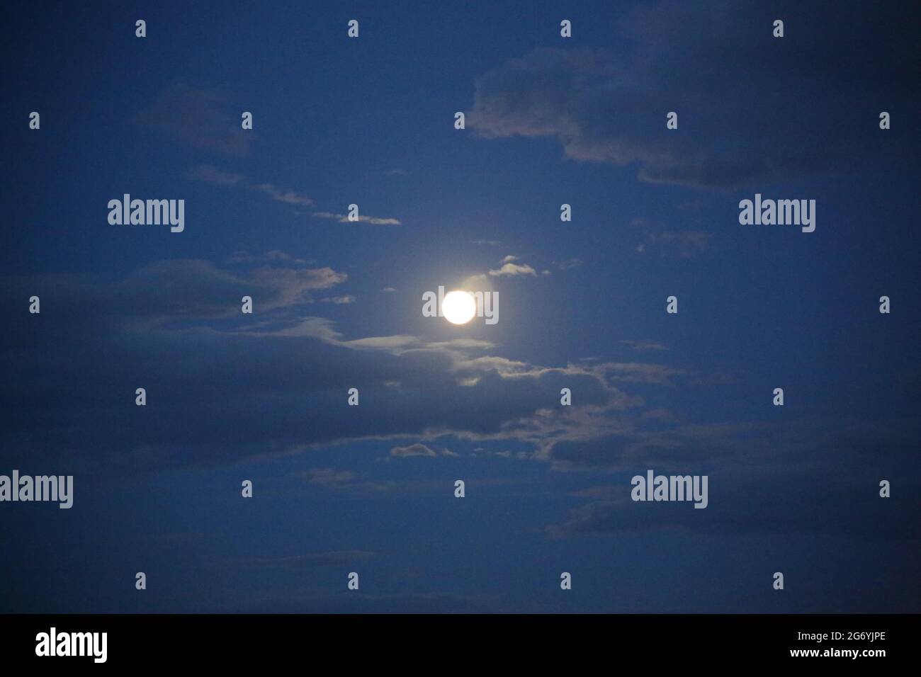 Glowing full moon up in the cloudy sky Stock Photo - Alamy