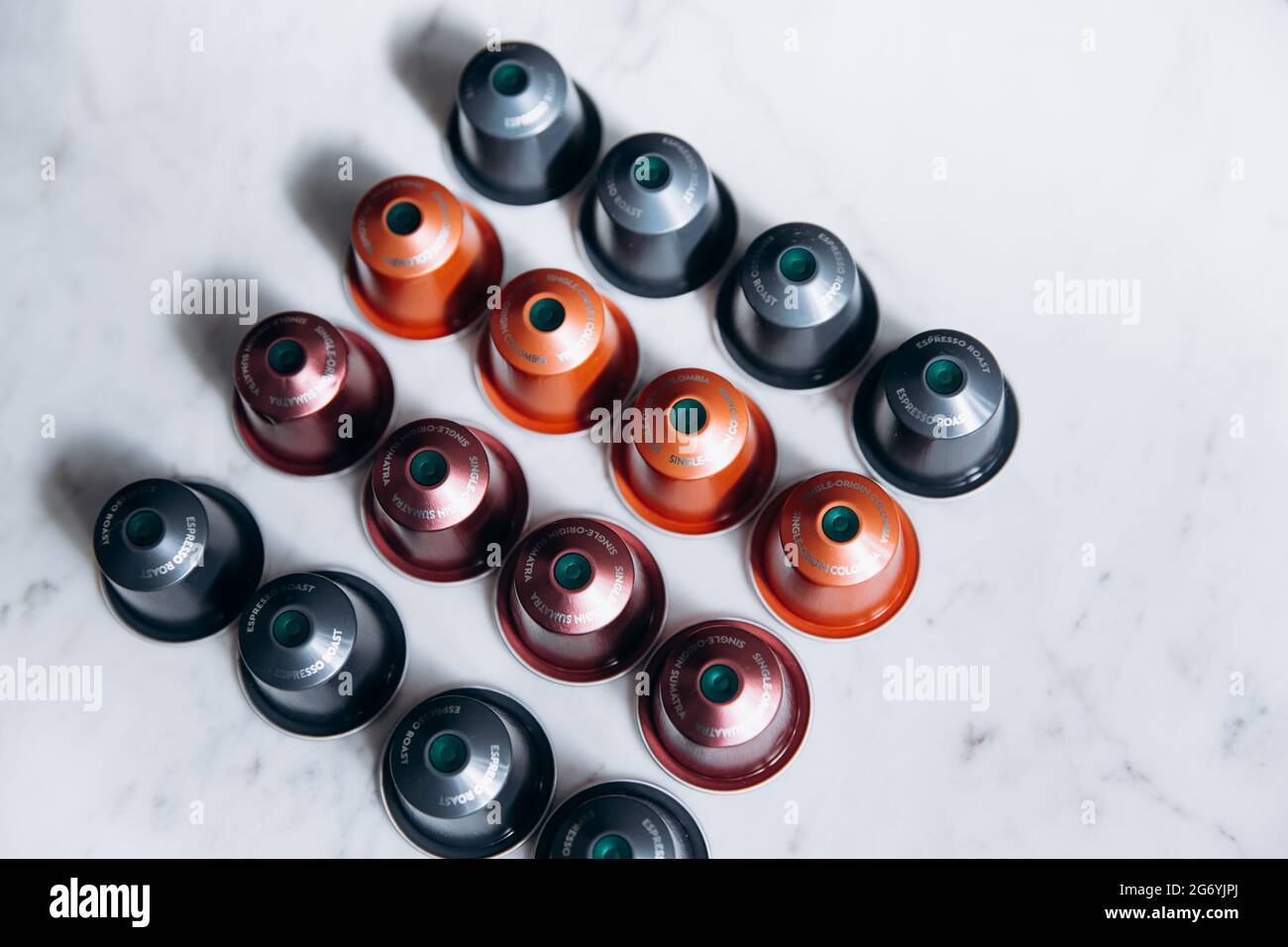 Collection of coffee capsules arranged in four rows Stock Photo - Alamy
