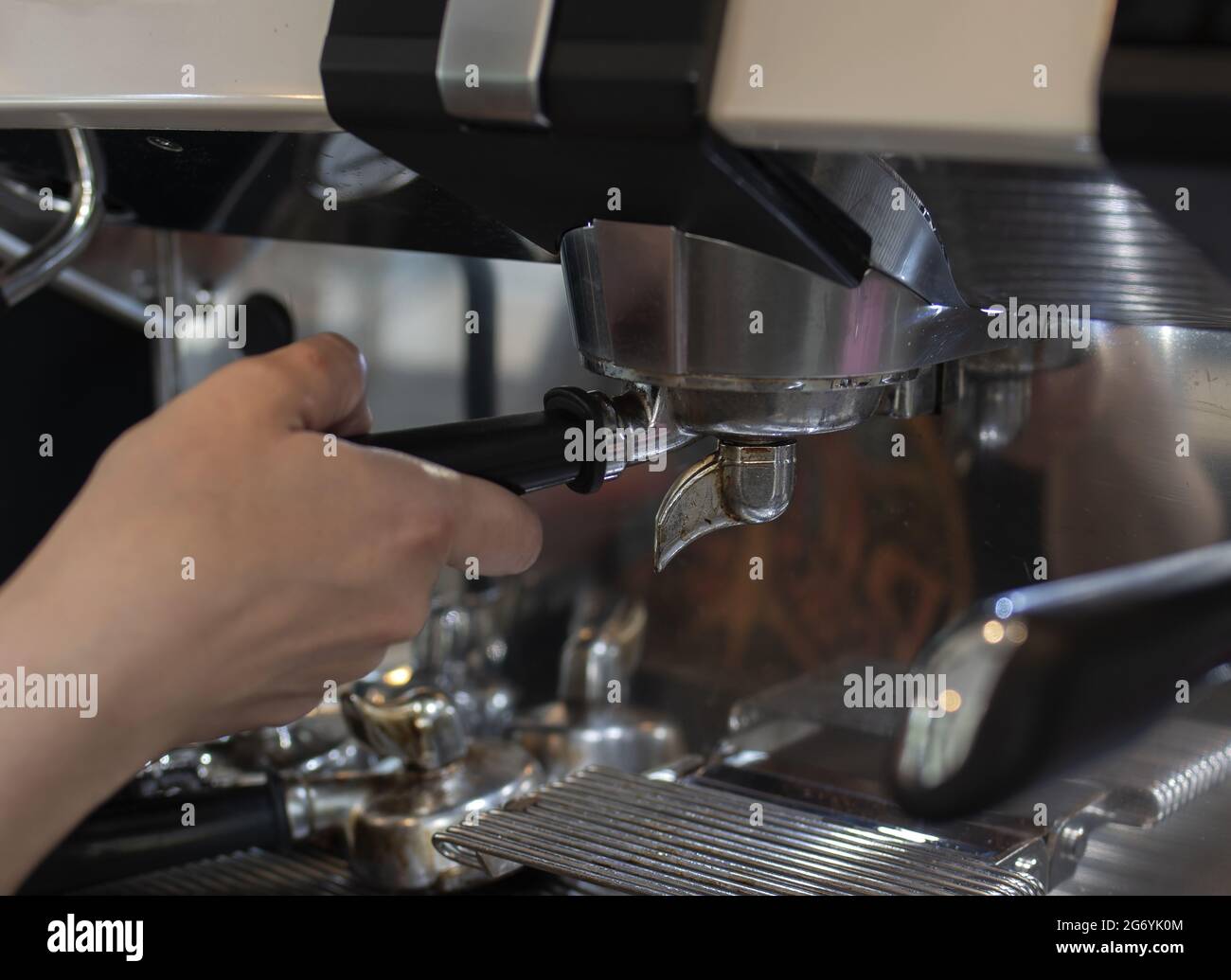Female's hand operating the Automatic Coffee machine to make coffee ...
