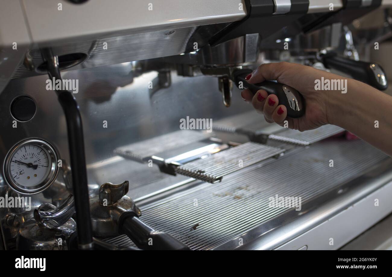 Female's hand operating the Automatic Coffee machine to make coffee ...