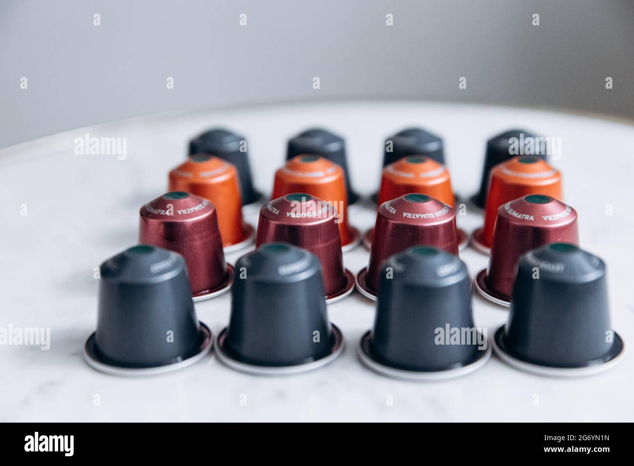 Four rows of coffee capsules on white background Stock Photo - Alamy