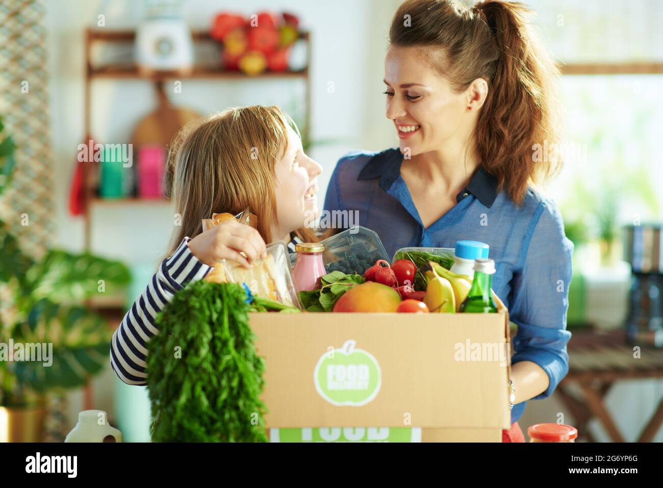 Food delivery. happy young mother and child with food box in the ...