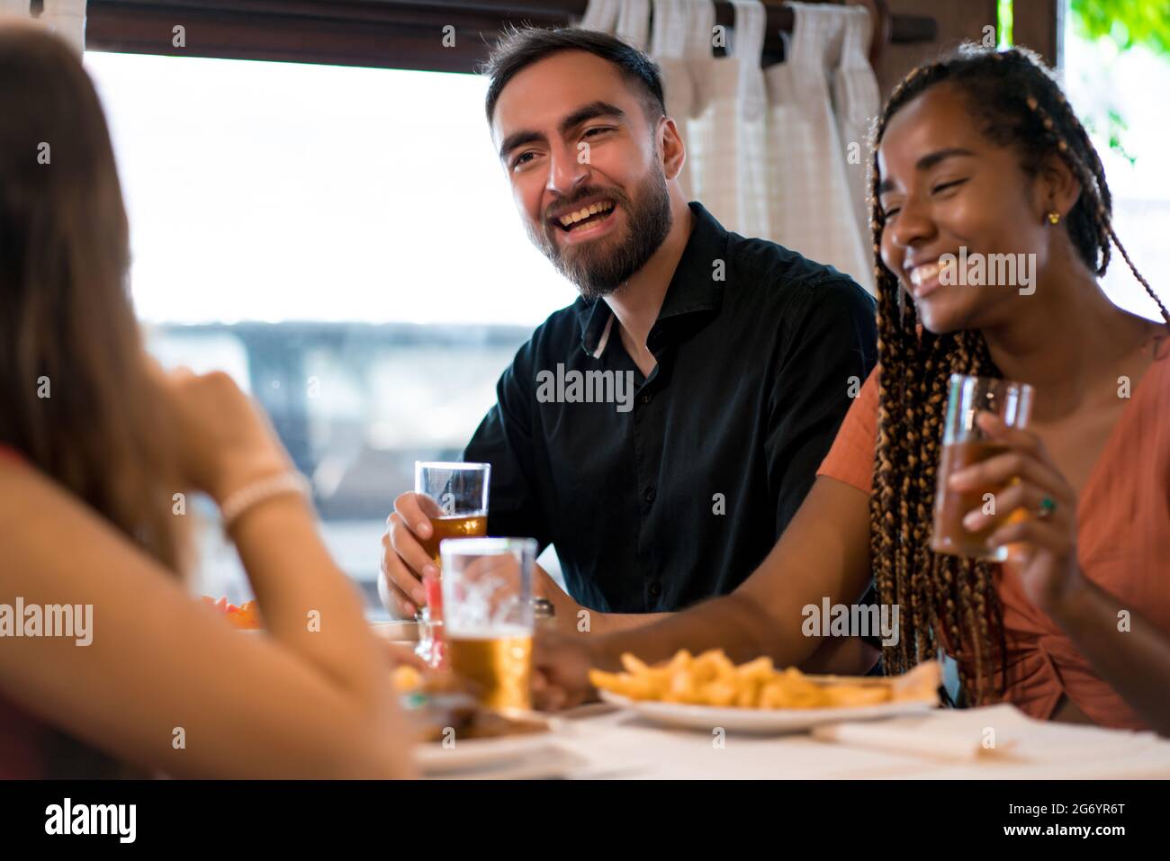 Group of friends enjoying drinking beer together at a bar Stock Photo ...