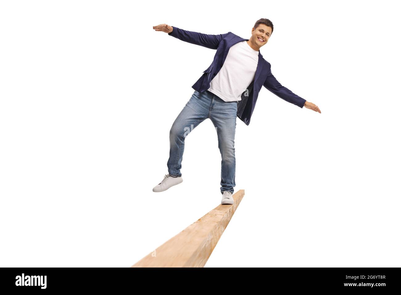 Full length shot of a young man walking on a wooden beam and keeping ...