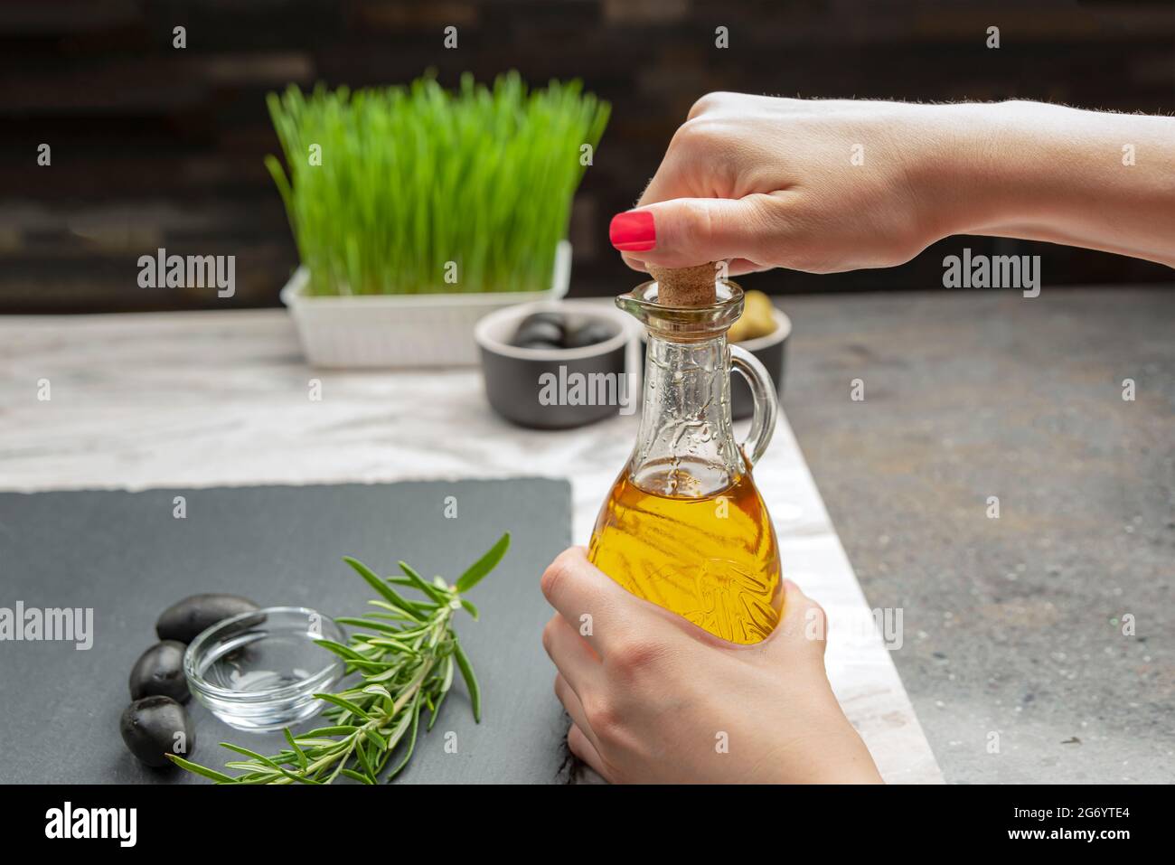 Olive oil. A woman pours olive oil into a saucer Stock Photo - Alamy
