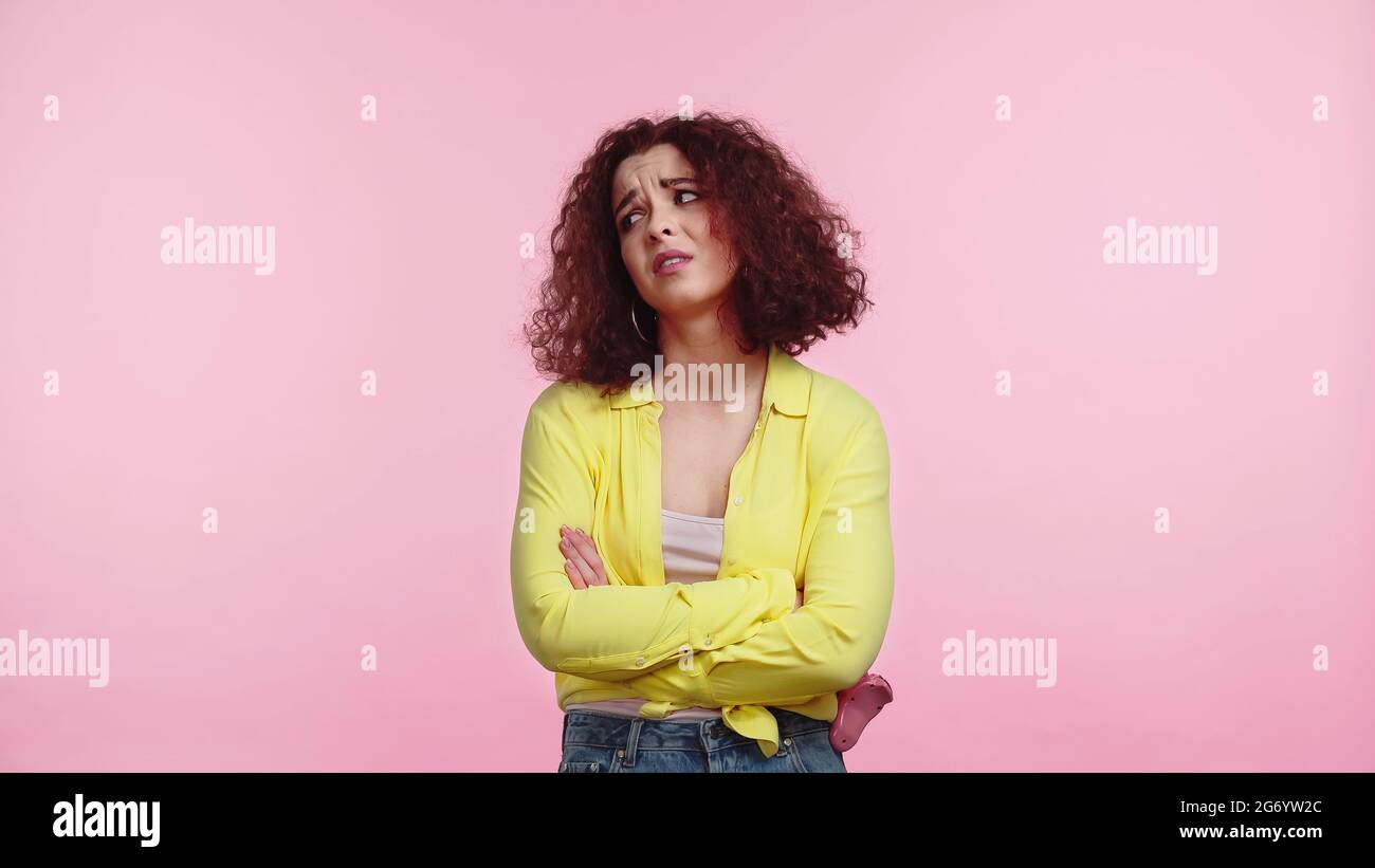 disappointed woman standing with crossed arms isolated on pink Stock ...