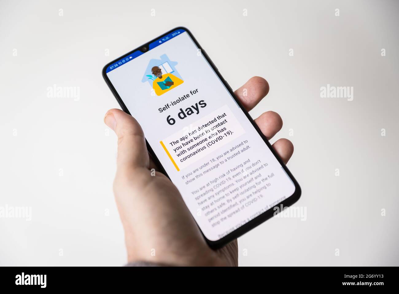 Hand holding a mobile showing a notification of self-isolation request ...