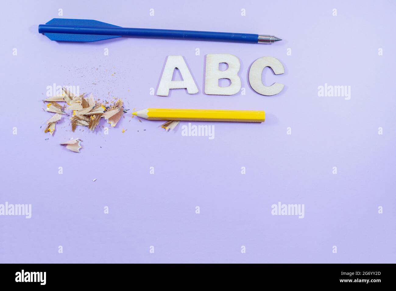 Closeup of letters "ABC" in between blue pen and yellow colored pencil ...
