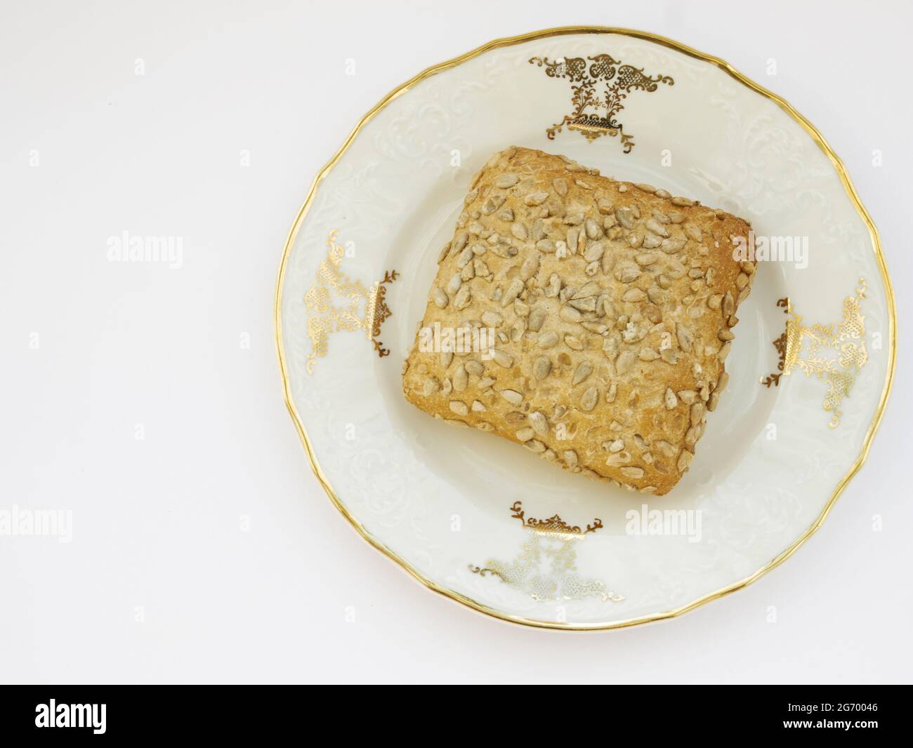 Sunflower bun on porcelain decorated plate on white background, photo ...