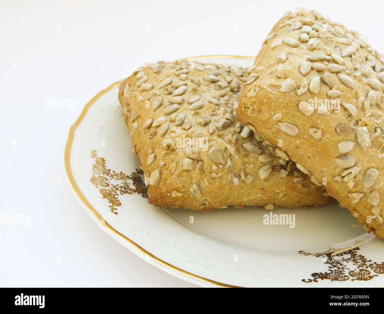 Sunflower bun on porcelain decorated plate on white background, photo ...