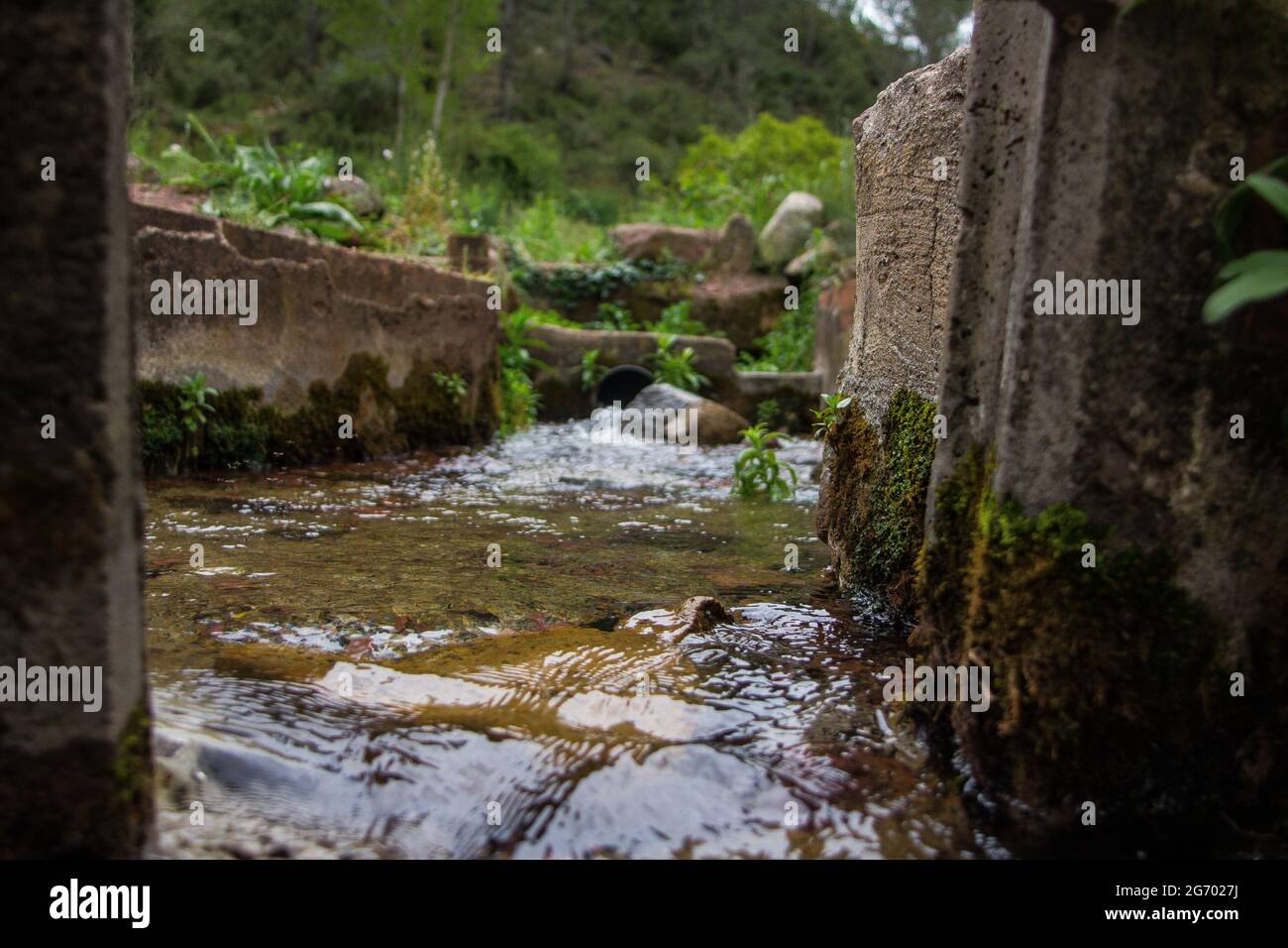 Closeup of a shallow water in the waterway surrounded by concrete ...