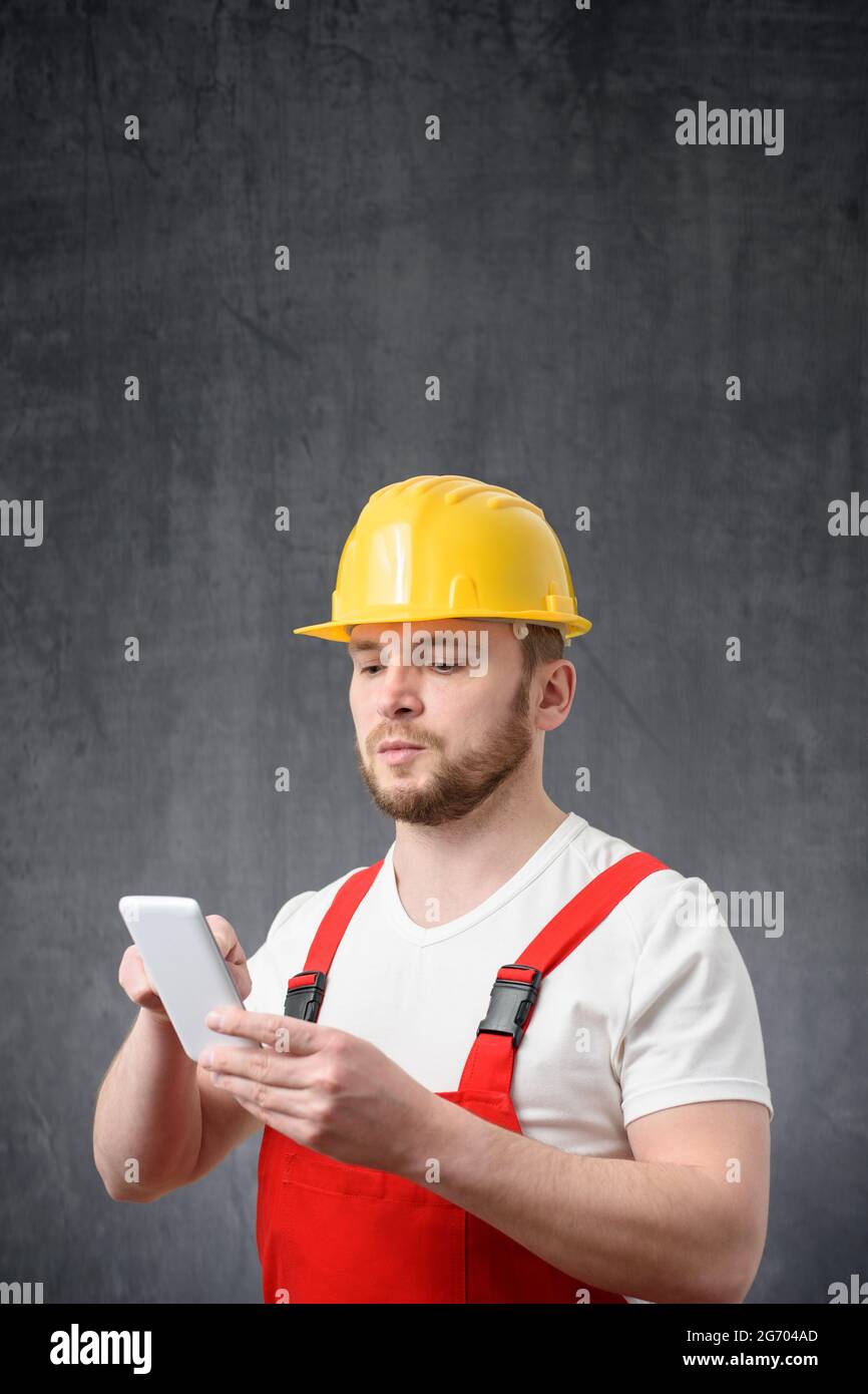 Portrait of a worker using his smartphone Stock Photo - Alamy