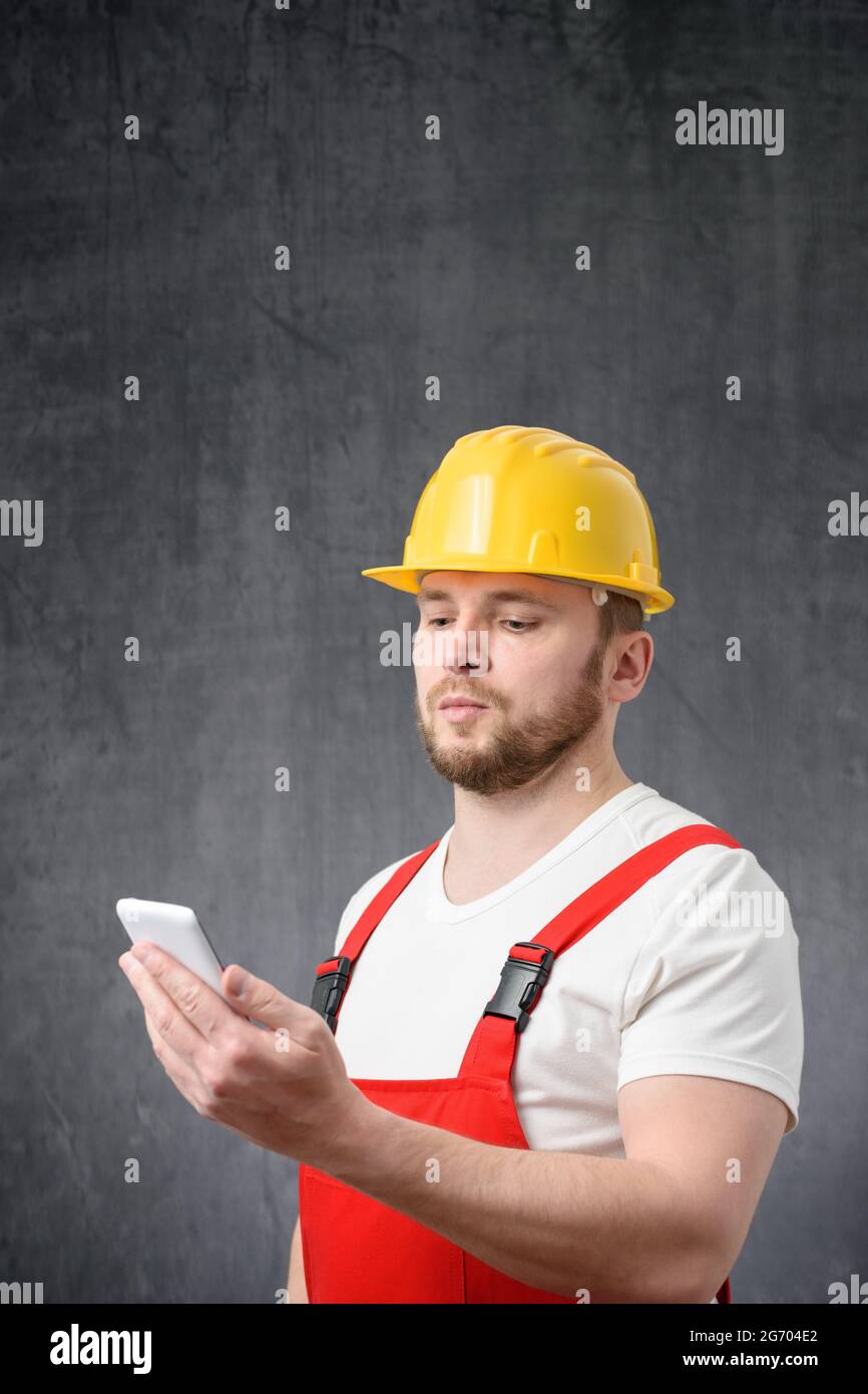 Portrait of a worker using his smartphone Stock Photo - Alamy