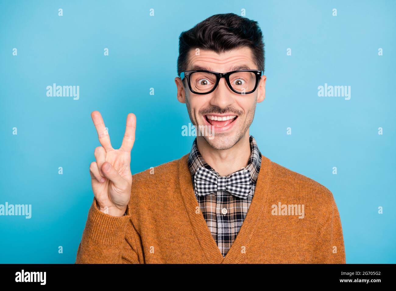 Photo of cheerful handsome young man hold v-sign good mood nerd geek ...