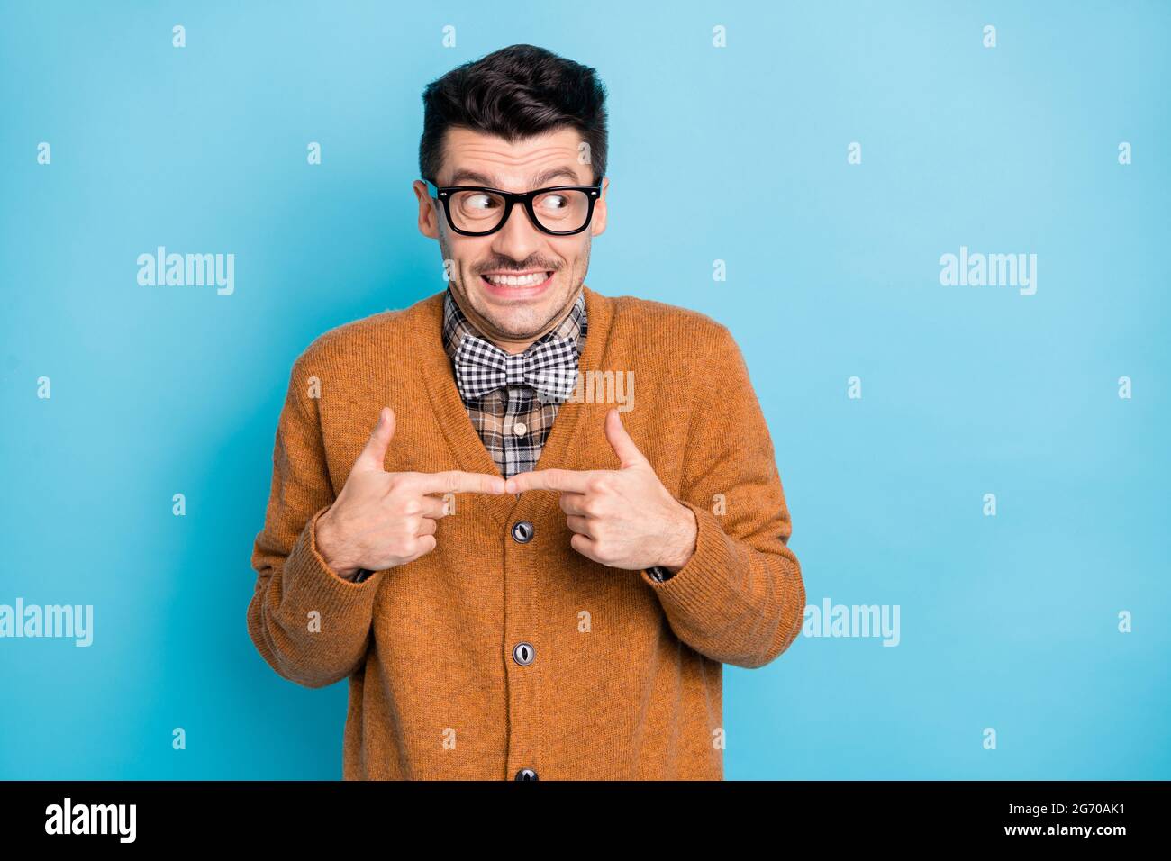 Photo of shy attractive young man touch fingers look empty space dream ...