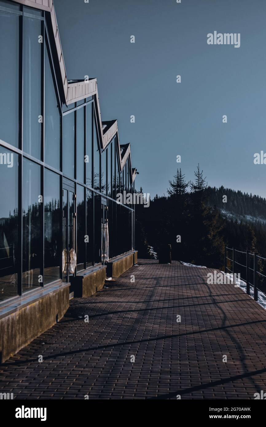 Side view of a modern commercial building with reflective glass windows ...