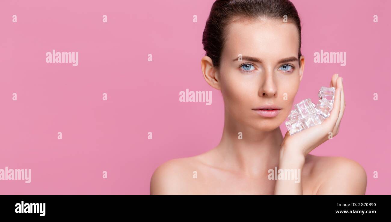 Beautiful woman with natural looking makeup holding ice cubes near face ...