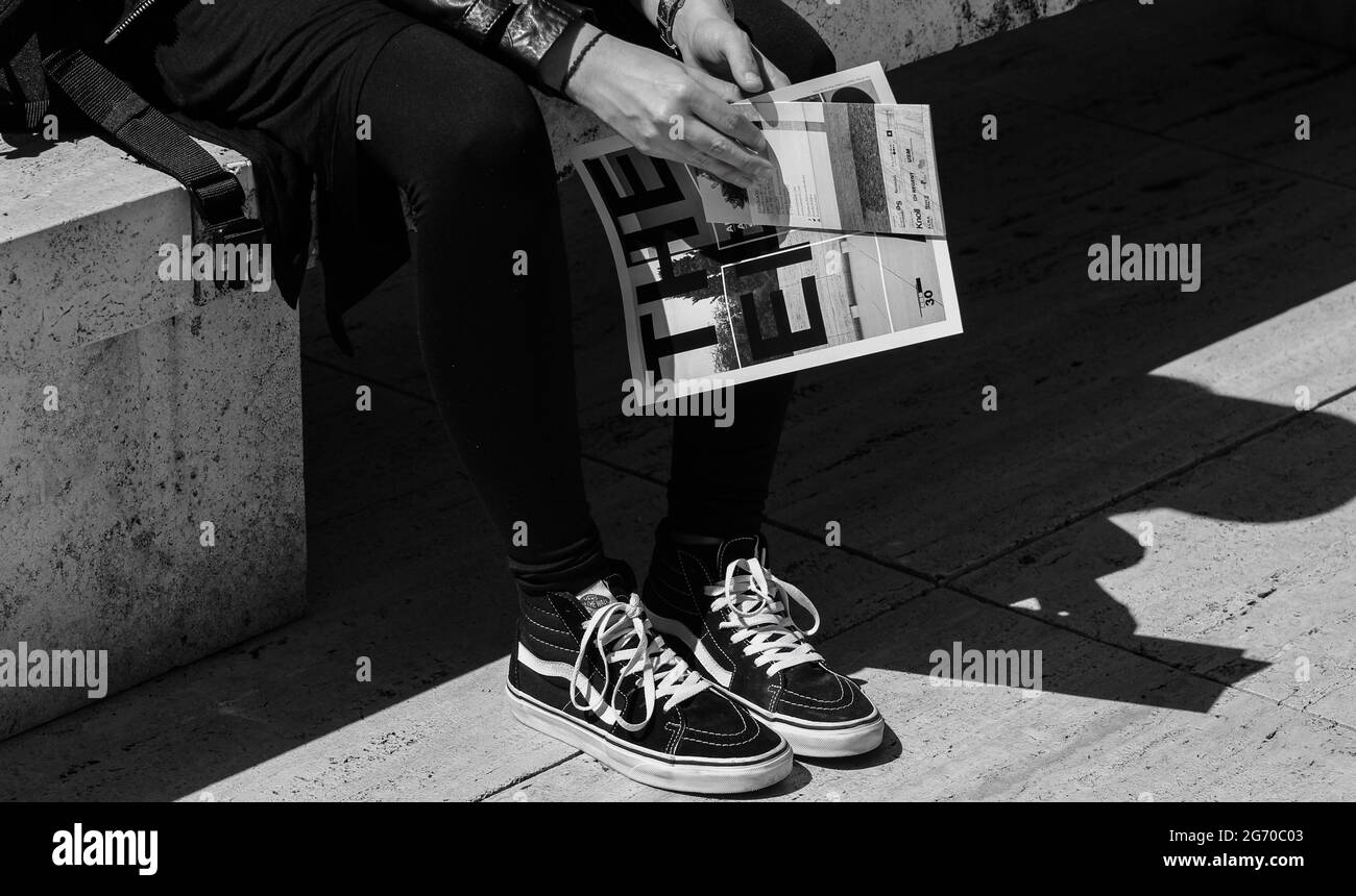 Person reading a magazine seated in black and white Stock Photo - Alamy